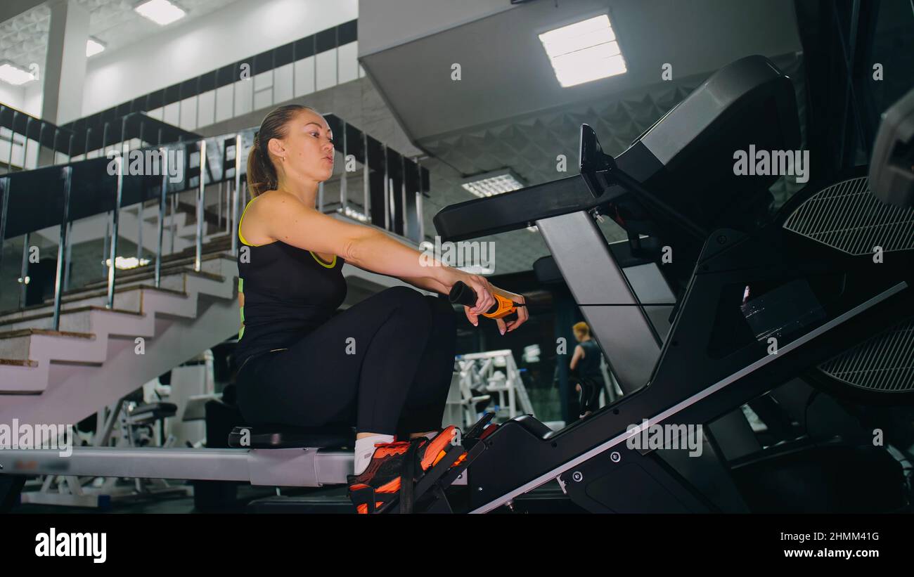 Fit Athletic Baby Woman Work out on Rowing Machine, Doing Her Fitness ...