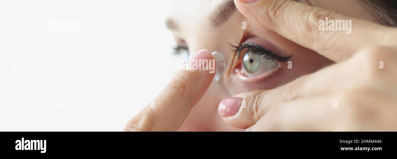 Young woman inserting contact lens into her eye closeup Stock Photo - Alamy