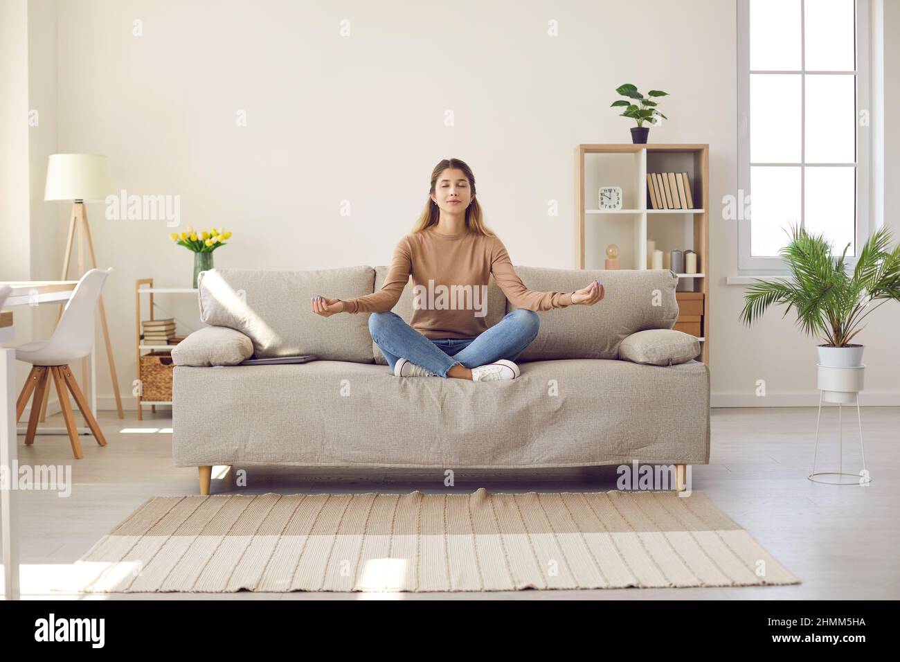 Calm woman practice yoga meditate on couch Stock Photo - Alamy