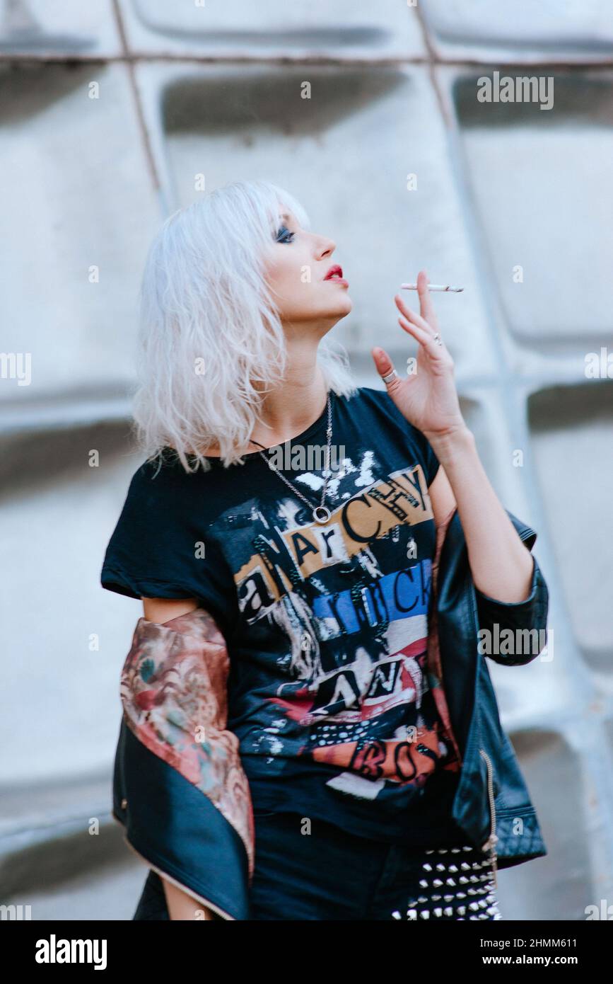 Portrait of stylish blonde grunge young woman with make up smoking ...
