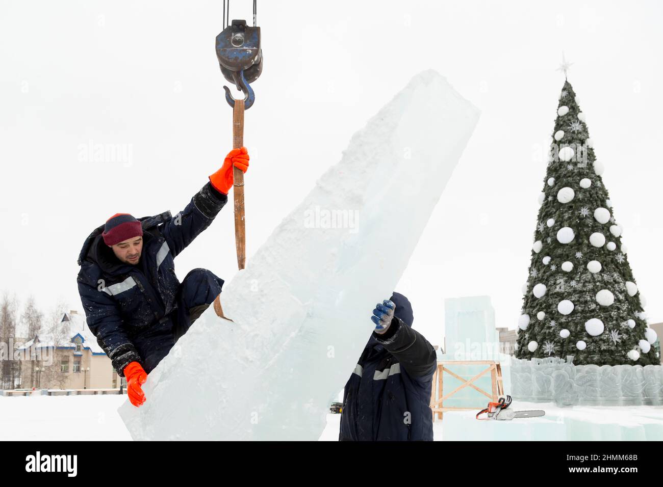 The installer stands on the ice block holding on to the tape sling ...