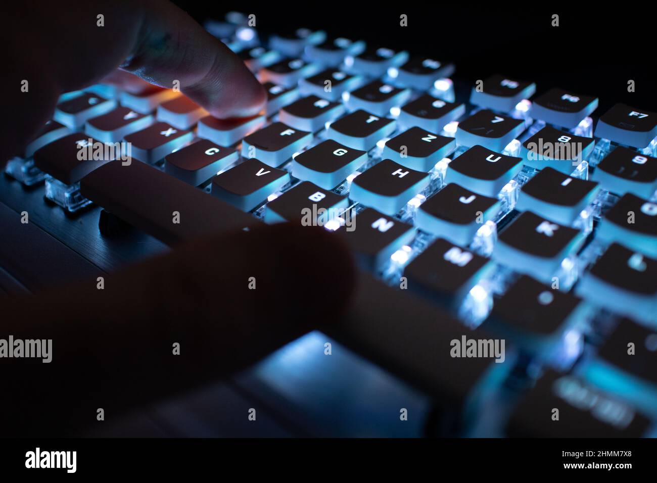 Male's hand typing on a keyboard with light up keys Stock Photo - Alamy