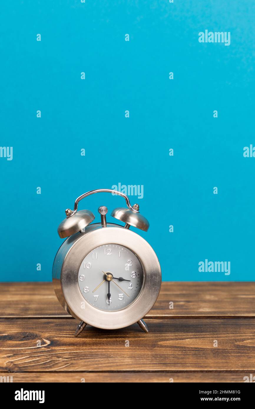 Vertical shot of a clock on the blue background Stock Photo - Alamy