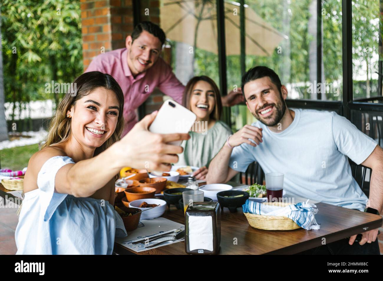 Mexican woman taking a photo selfie with group of latin friends and ...