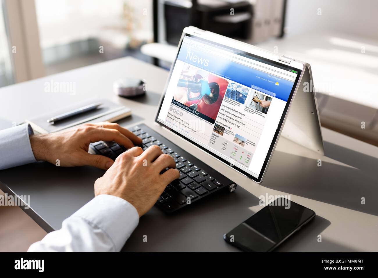 Man reading newspaper working laptop hi-res stock photography and ...