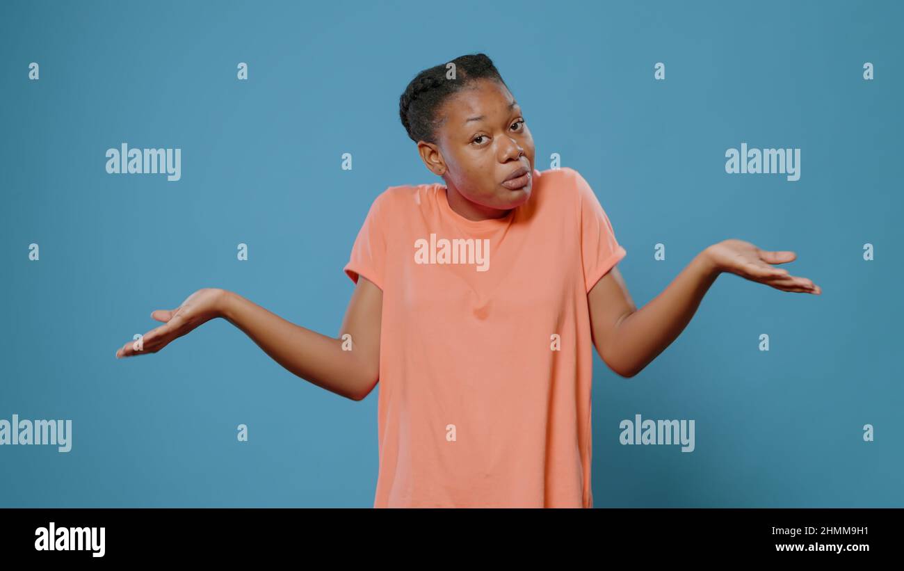 Confused adult raising hands and shoulders in studio, being unsure ...