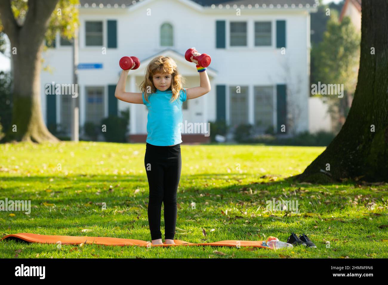 Child boy working out with dumbbells on park background. Kids sport ...