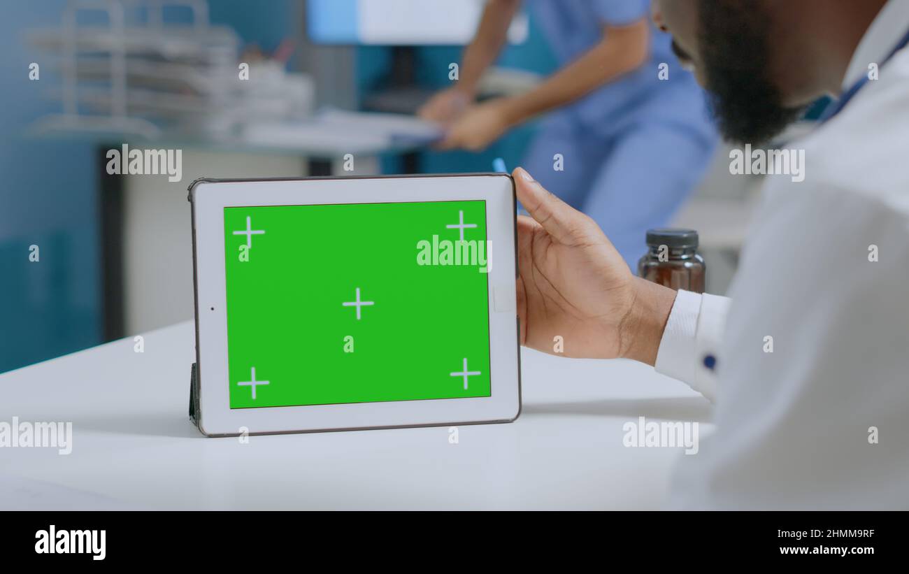 African american specialist doctor looking at mock up green screen ...