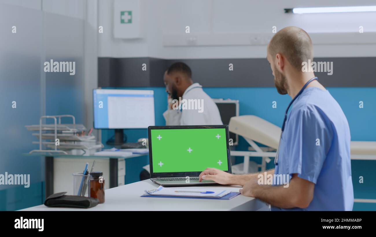 Therapist man nurse sitting at desk typing sickness expertise on mock ...