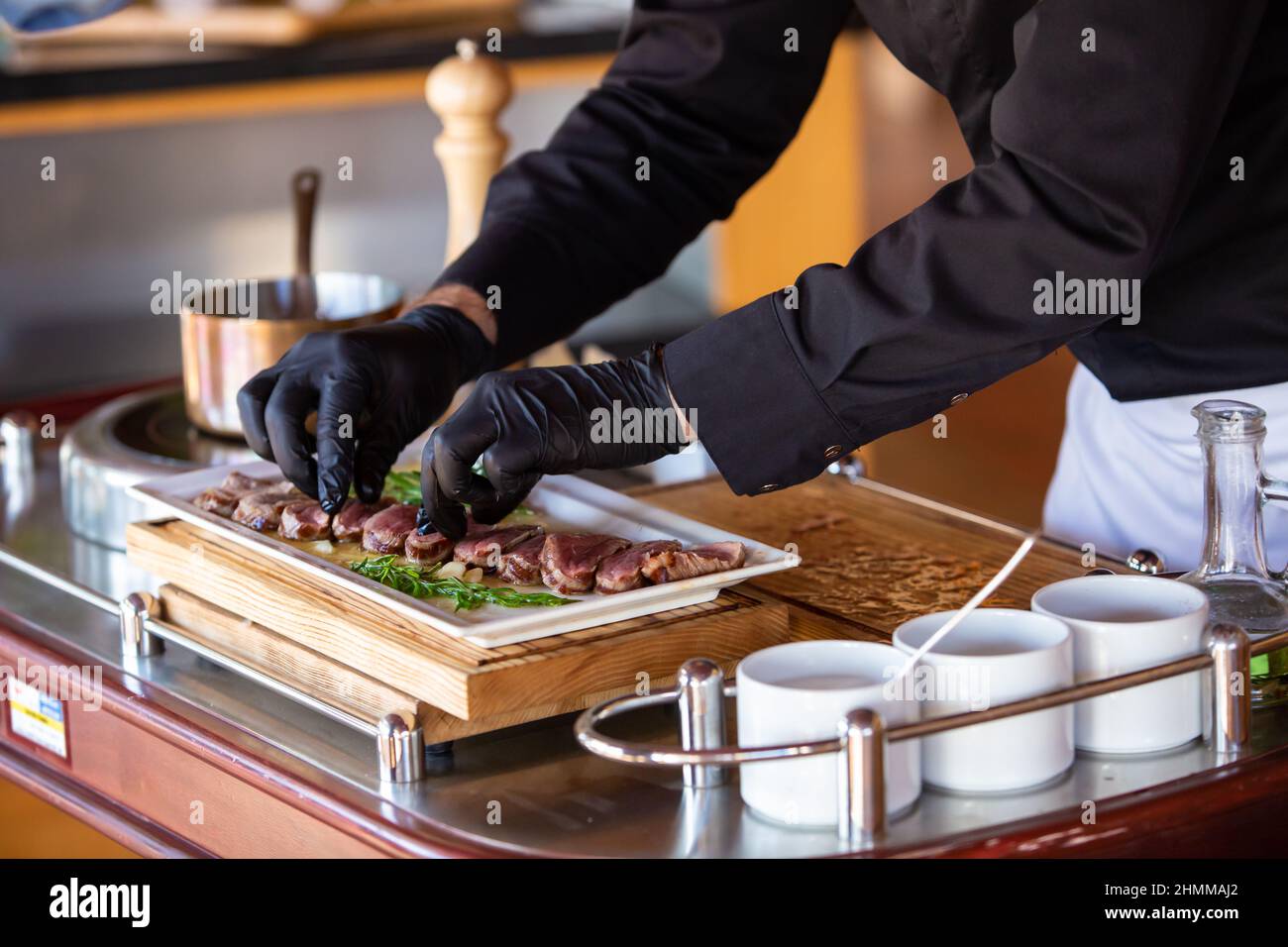 the chef prepares a steak in the restaurant hall Stock Photo - Alamy