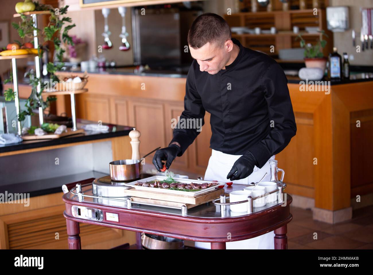 the chef prepares a steak in the restaurant hall Stock Photo - Alamy