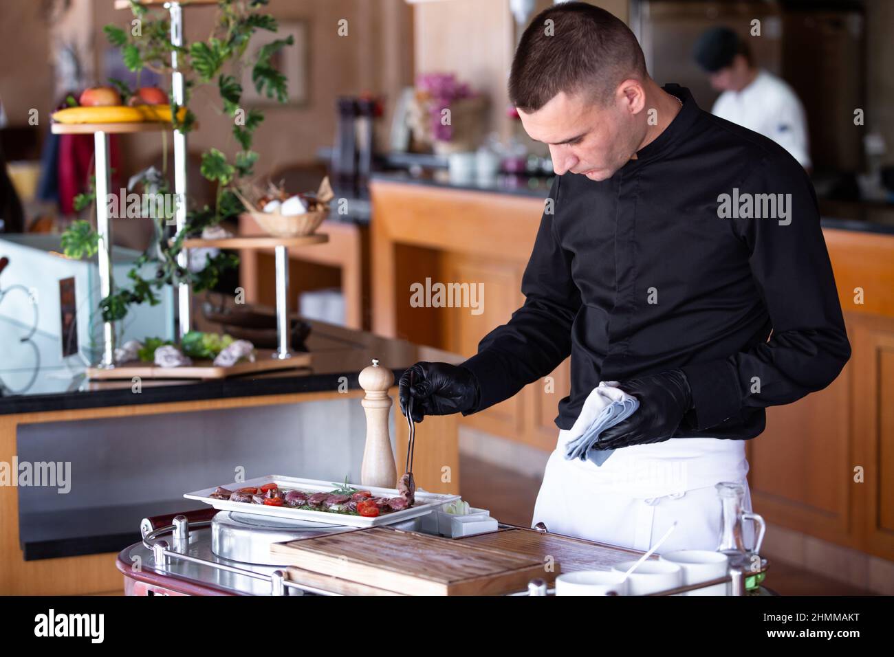 the chef prepares a steak in the restaurant hall Stock Photo - Alamy