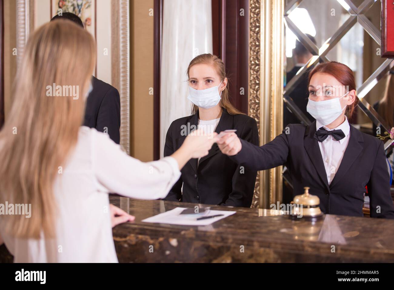 the hotel staff serves guests in medical masks Stock Photo - Alamy