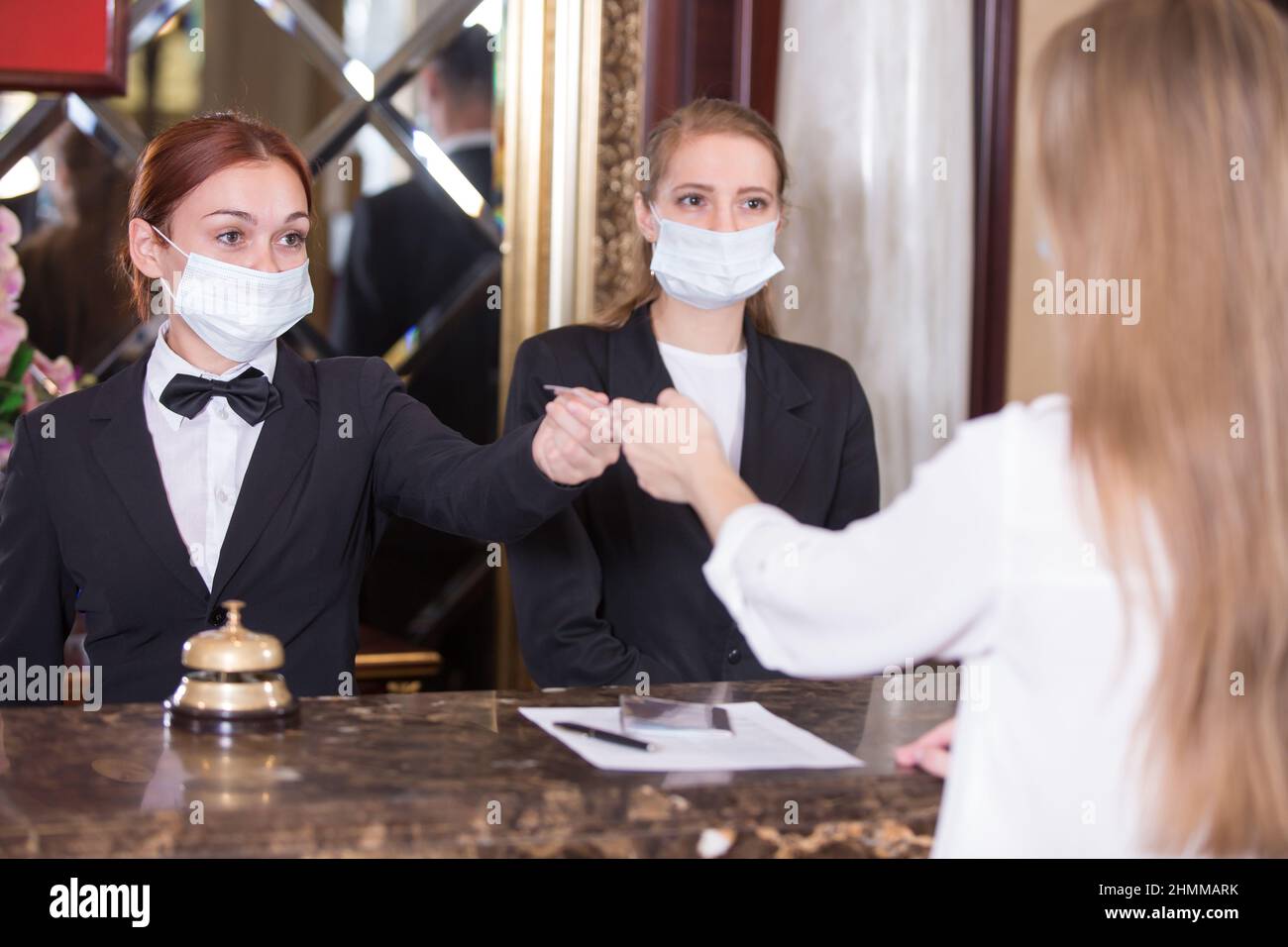 the hotel staff serves guests in medical masks Stock Photo - Alamy