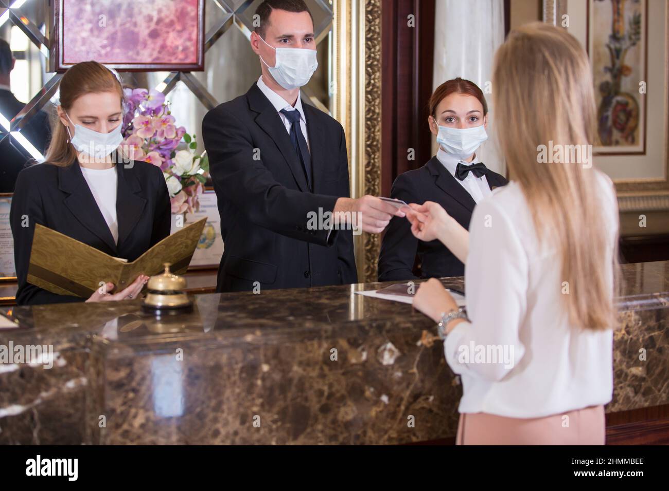 the hotel staff serves guests in medical masks Stock Photo - Alamy