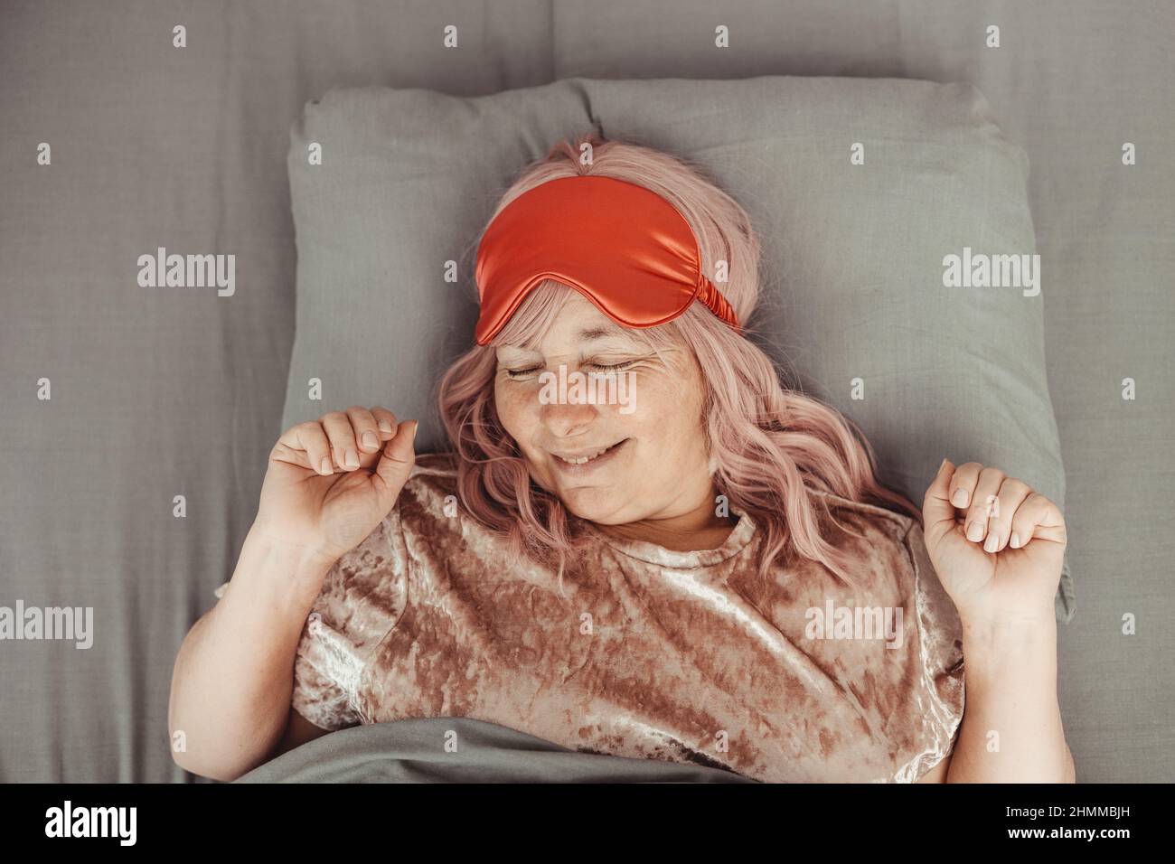 Beautiful 50s woman sleeping in bed early in morning. People, relax and ...