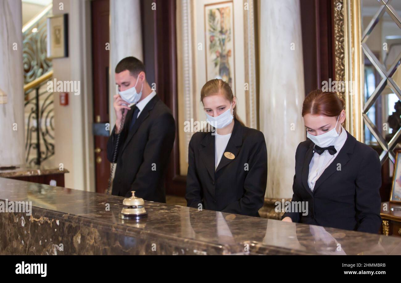 the hotel staff serves guests in medical masks Stock Photo - Alamy