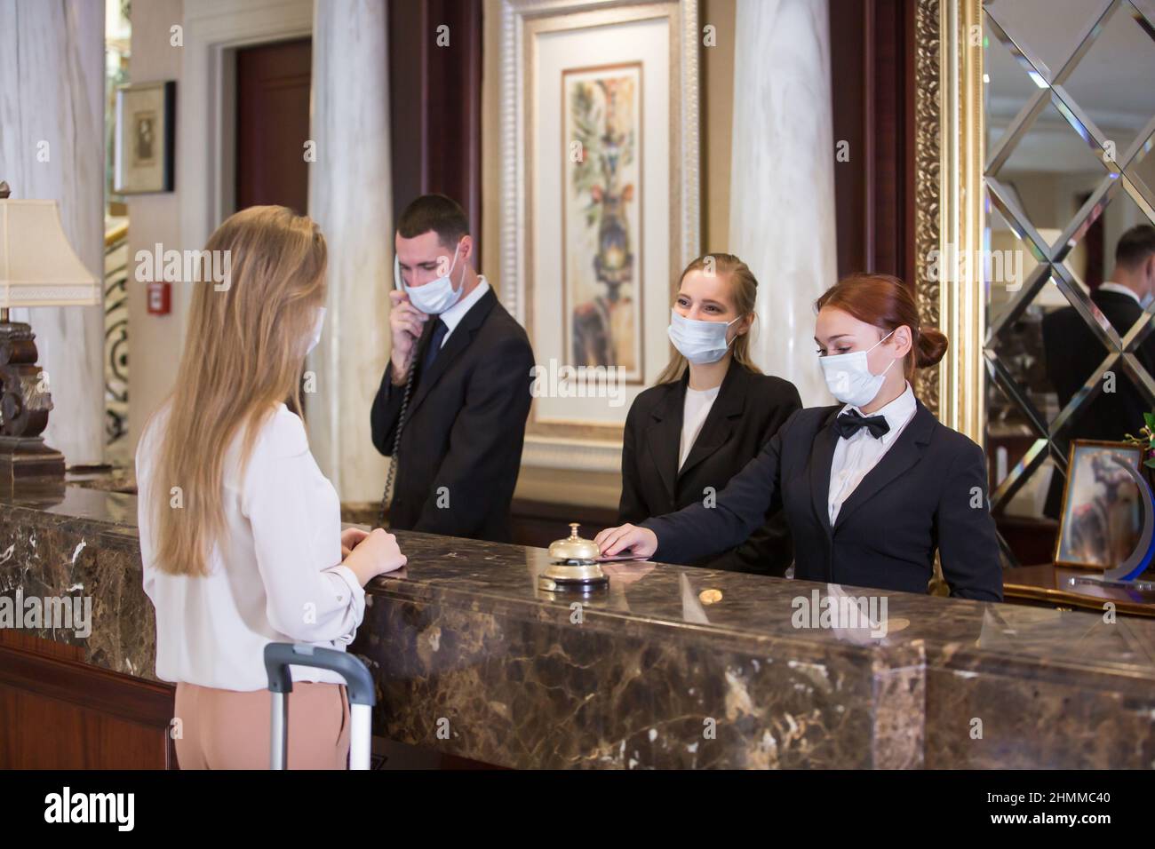 the hotel staff serves guests in medical masks Stock Photo - Alamy