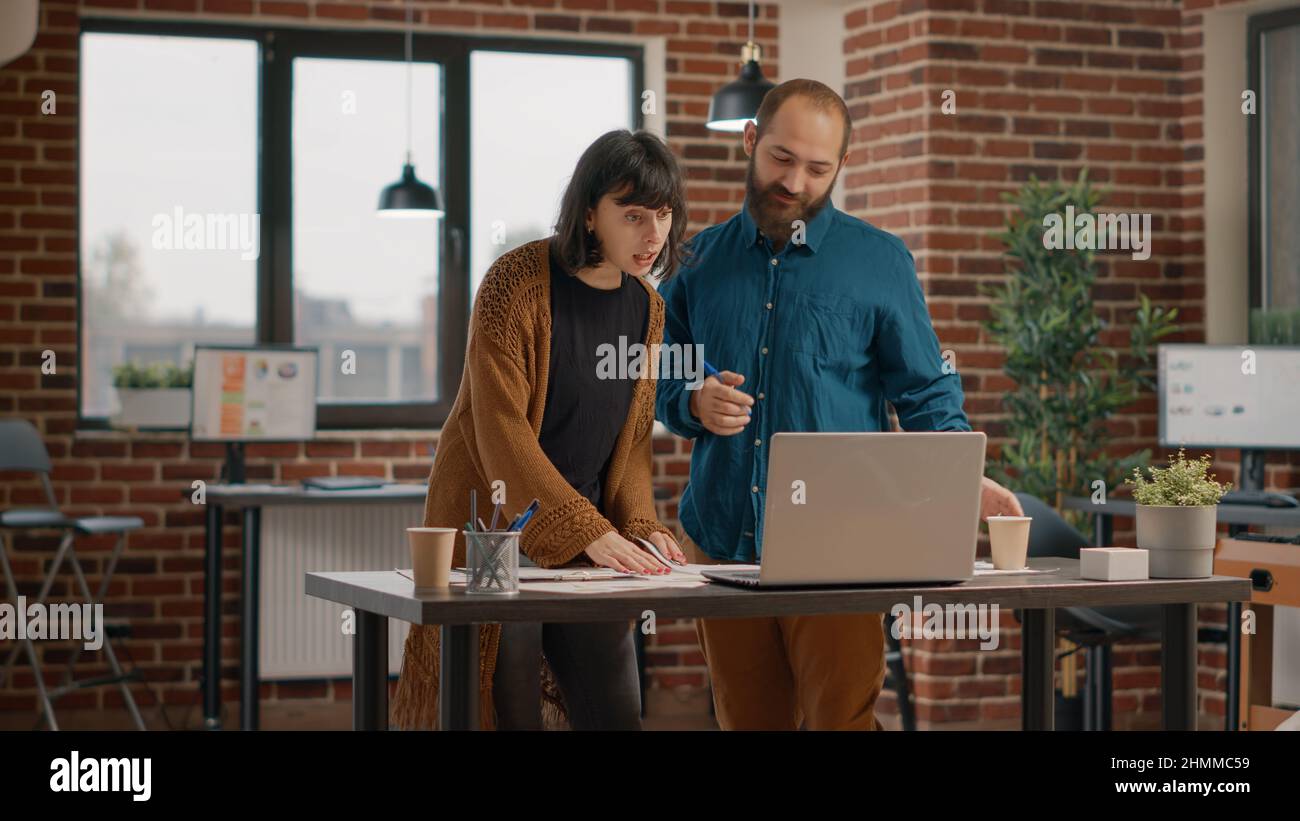 Workmates looking laptop screen charts hi-res stock photography and ...