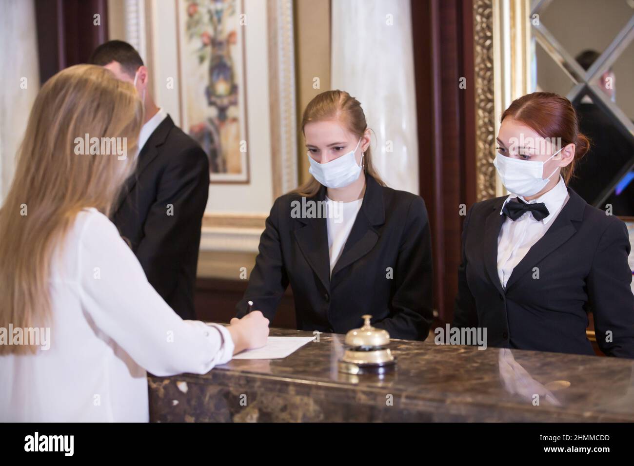 the hotel staff serves guests in medical masks Stock Photo - Alamy