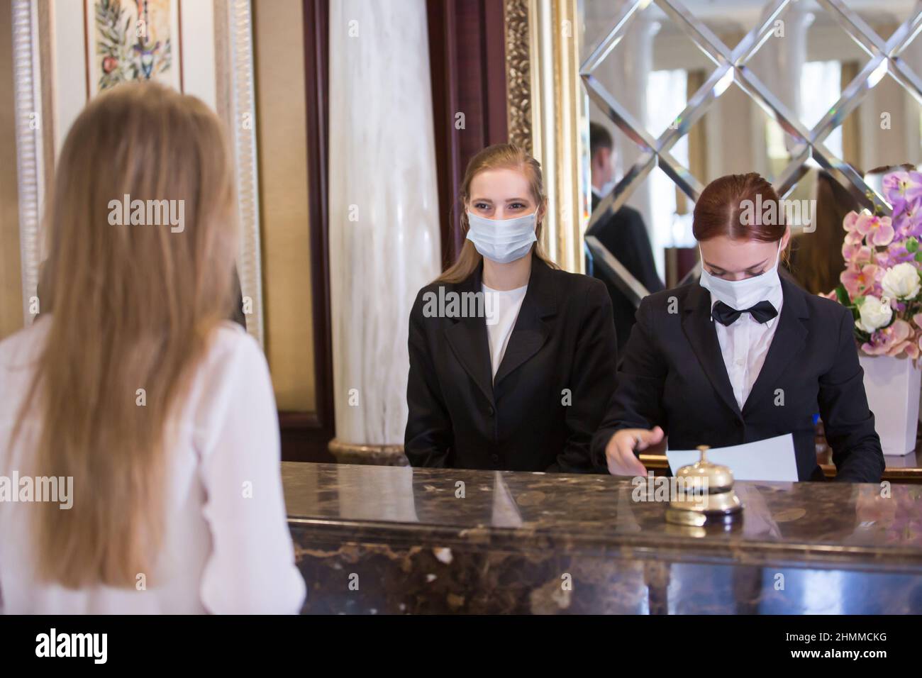 the hotel staff serves guests in medical masks Stock Photo - Alamy