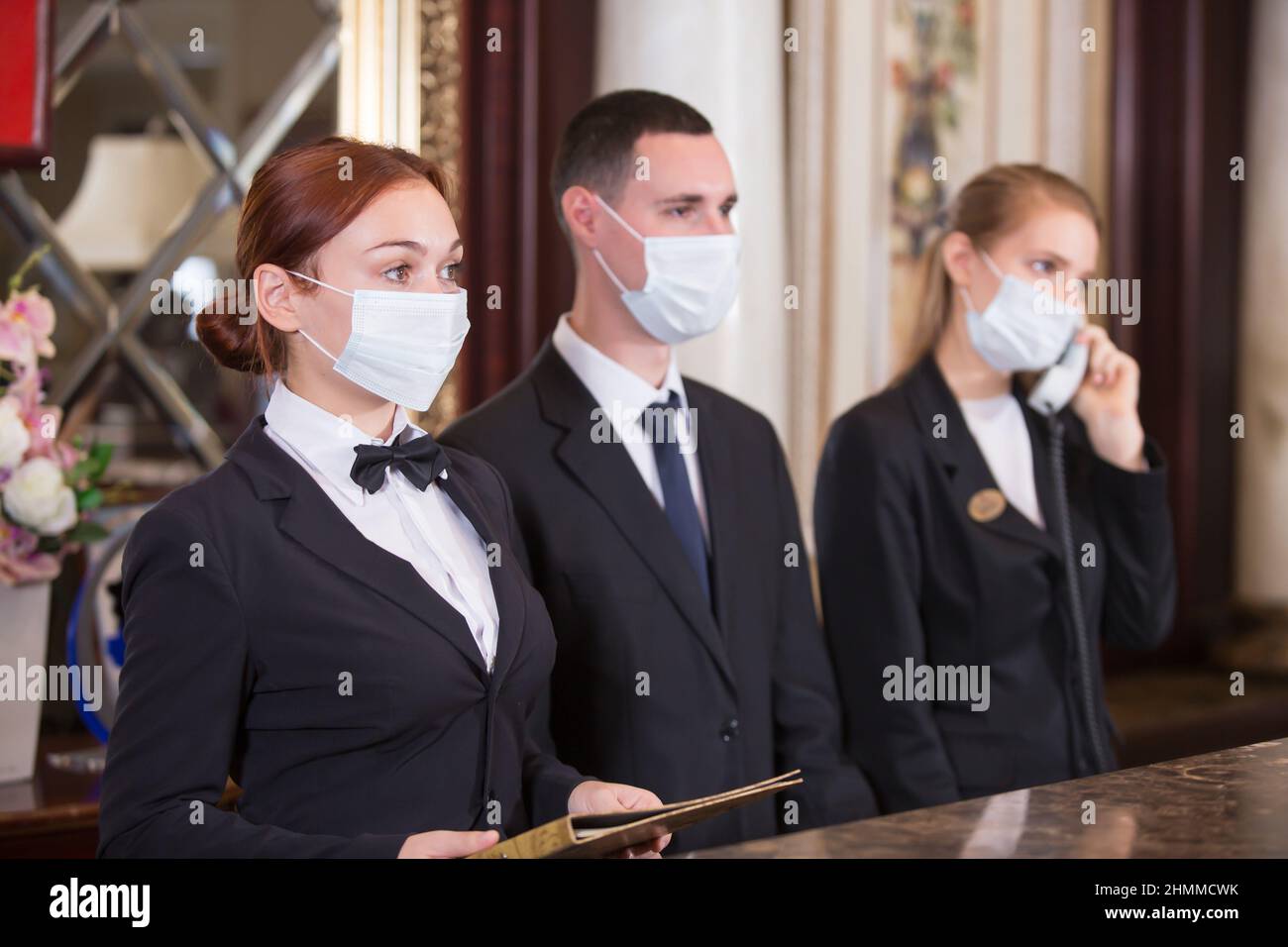 the hotel staff serves guests in medical masks Stock Photo - Alamy