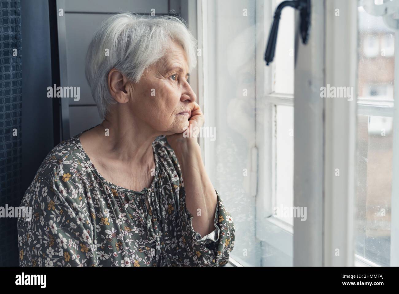 Elderly lady looking out window hi-res stock photography and images - Alamy