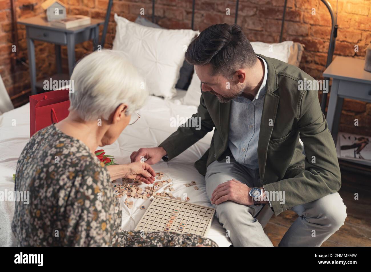 elderly grey-haired mother playing vocabulary games with her middle ...