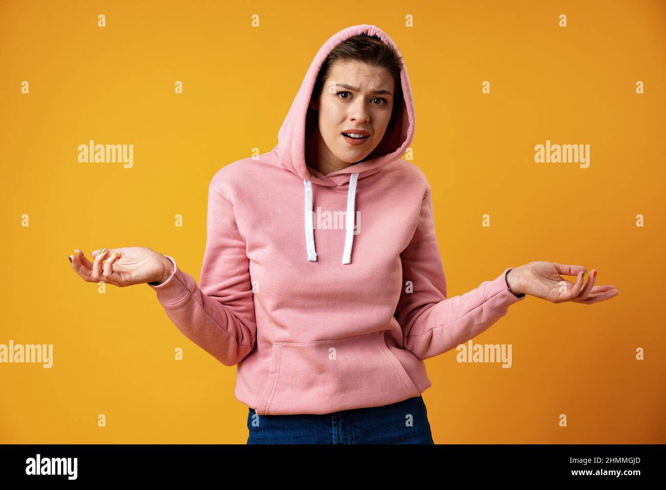 Studio portrait of awkward young woman feeling confused and puzzled ...