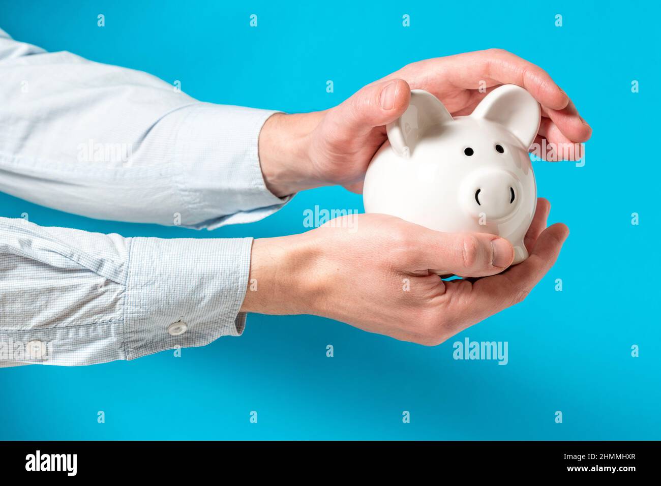 Protect your money concept. Two man's hands covering white piggy bank ...