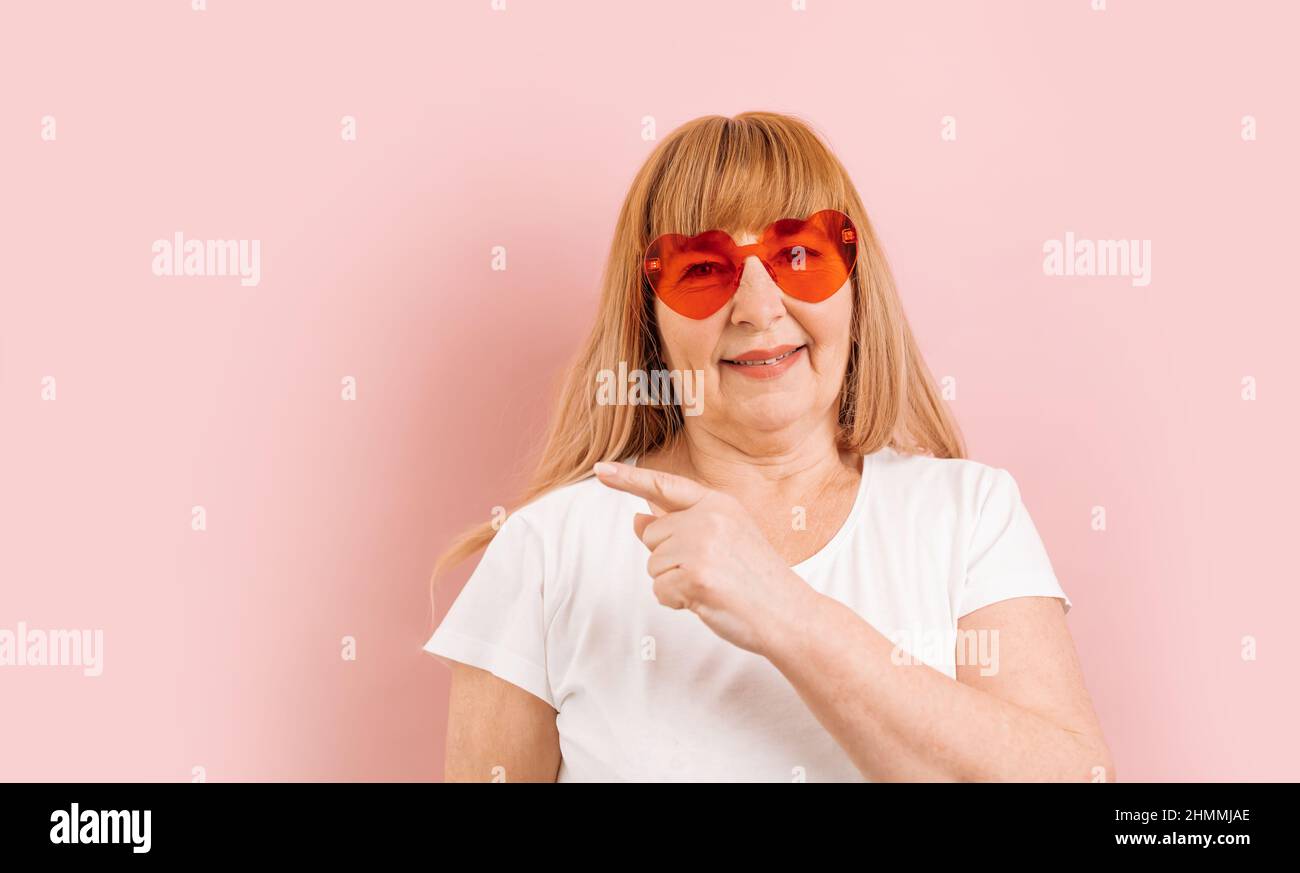 Attention promotions banner. Charming caucasian 40s 50s woman pointing ...