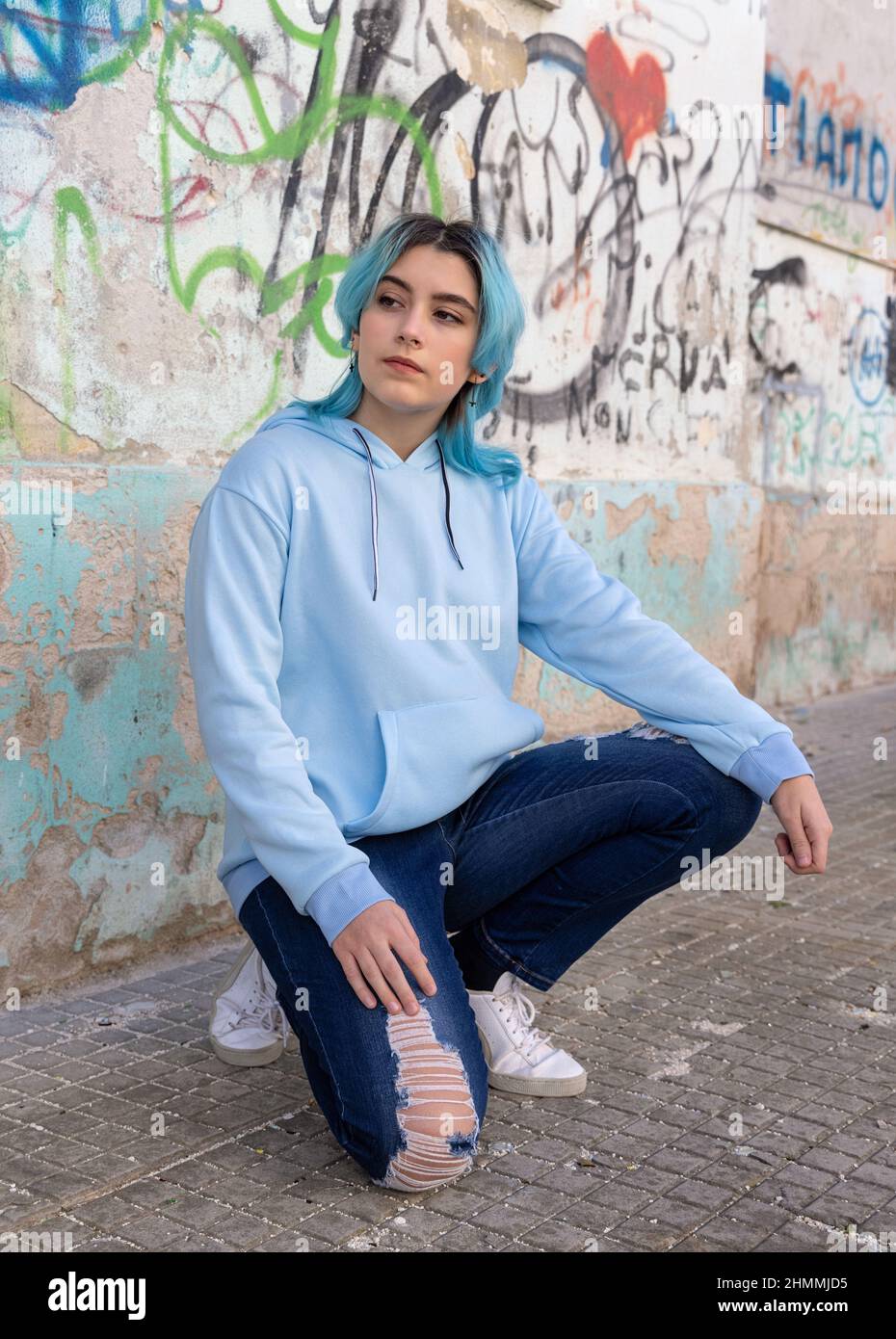 Blue haired Teenage girl in light blue oversize hoodie and looking ...