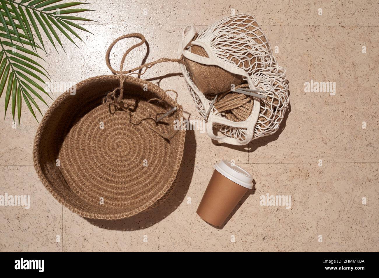 Jute crochet knitting bag, cup of coffee and shadows. Flat lay hobby ...