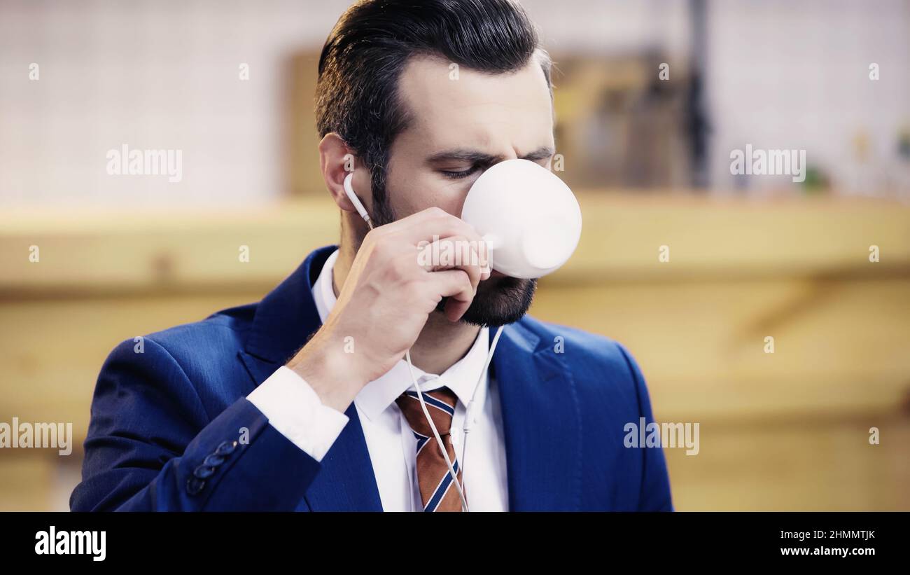 bearded businessman with earphone drinking coffee Stock Photo - Alamy