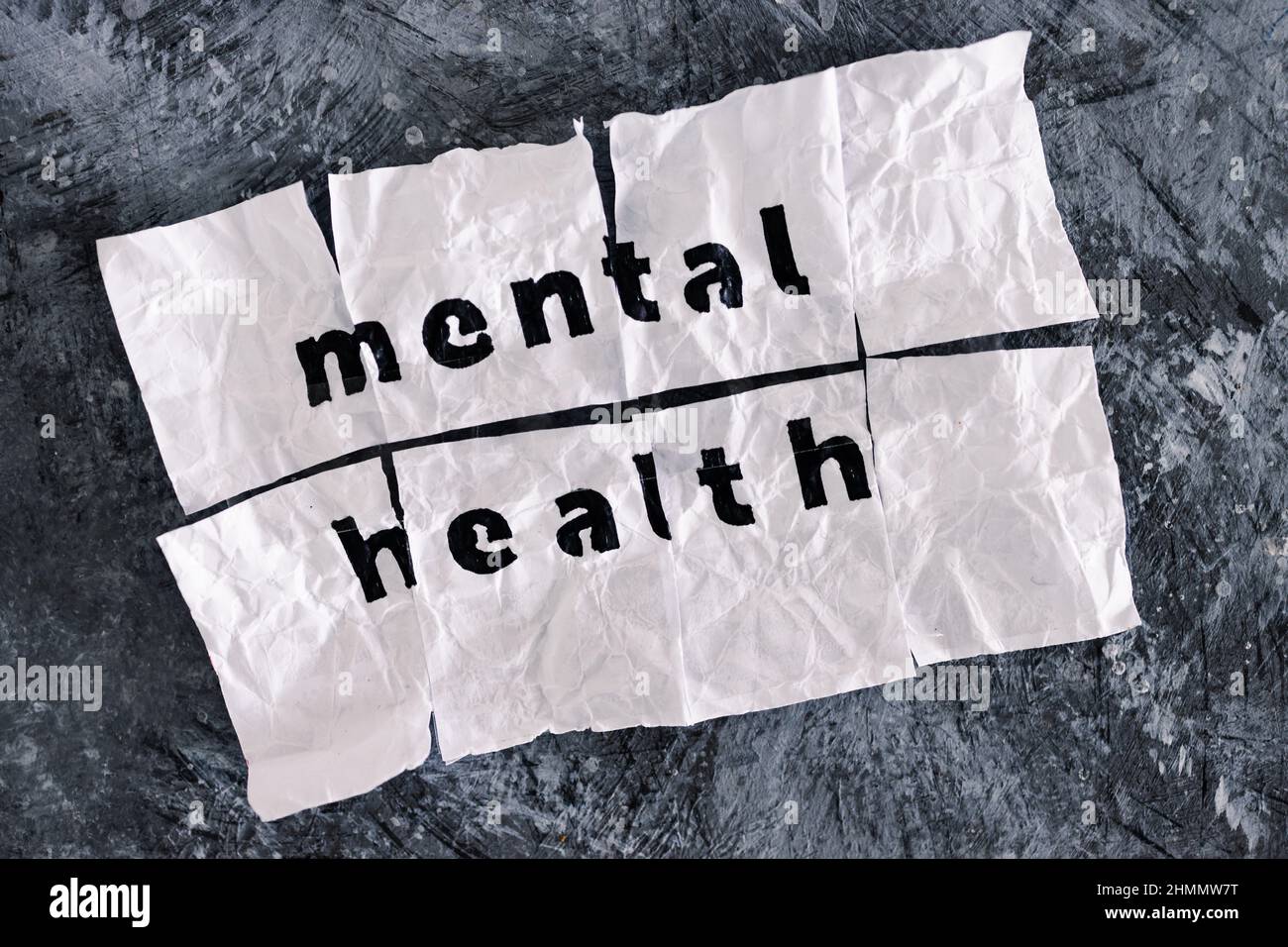 Mental health text on crumpled and torn piece of paper which has been ...
