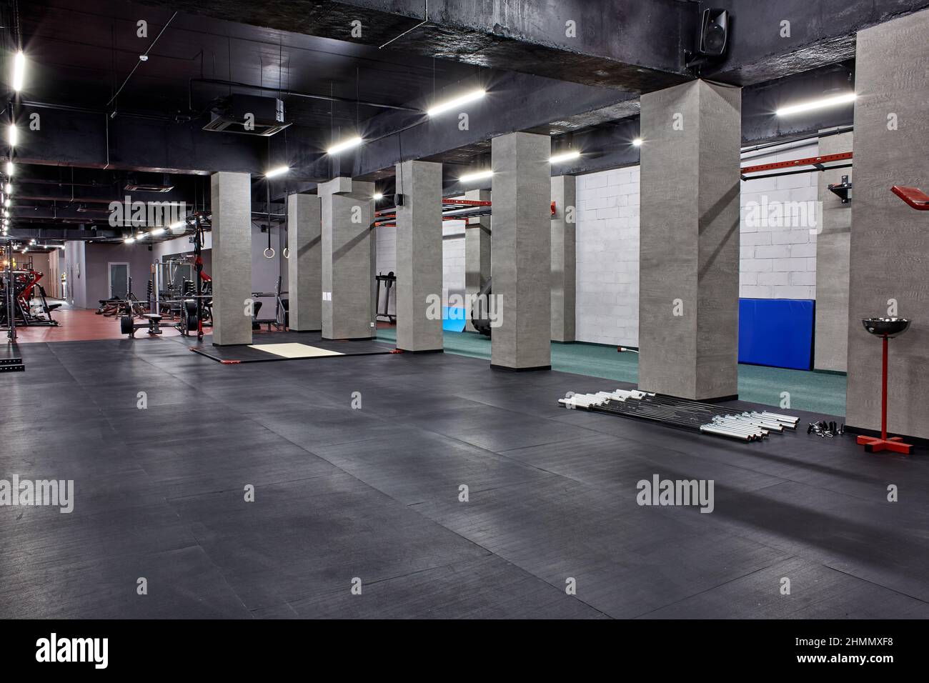 Spacious, well lit, gym interior with exercise machines for physical ...