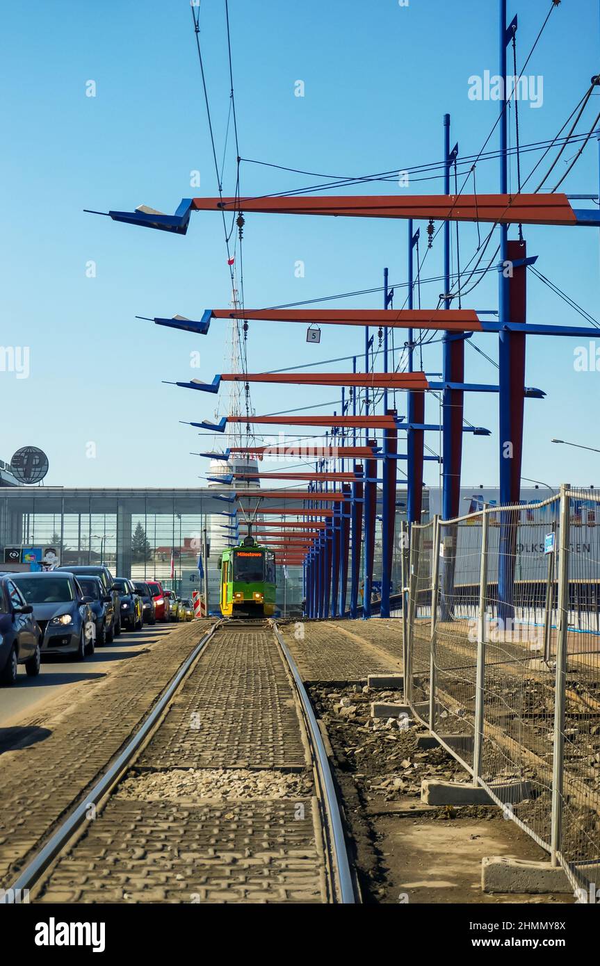 Green tram on tracks next to waiting cars in the city center Stock ...
