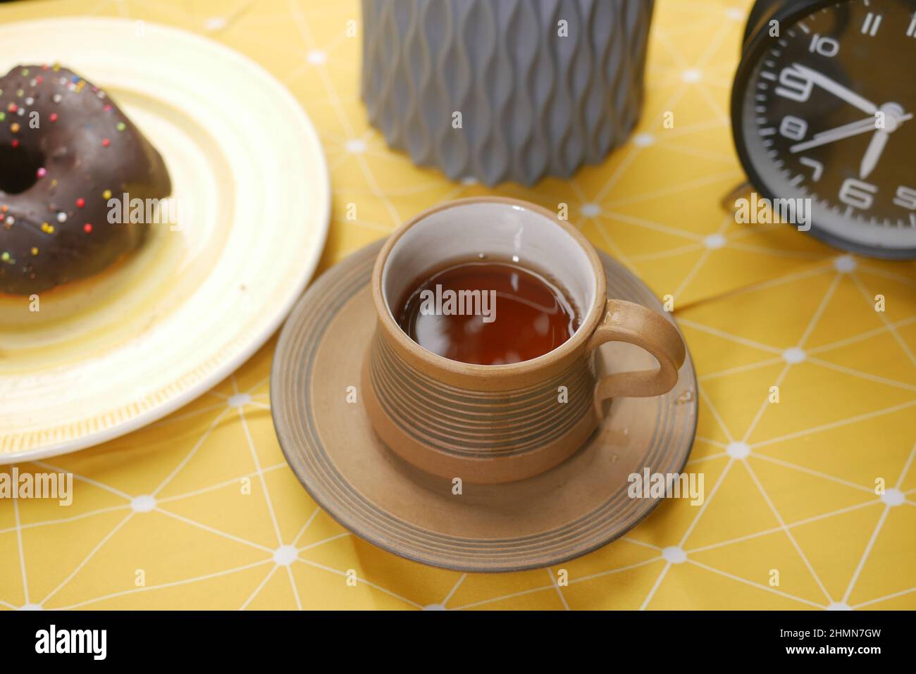 green tea, donuts and clock on table Stock Photo - Alamy