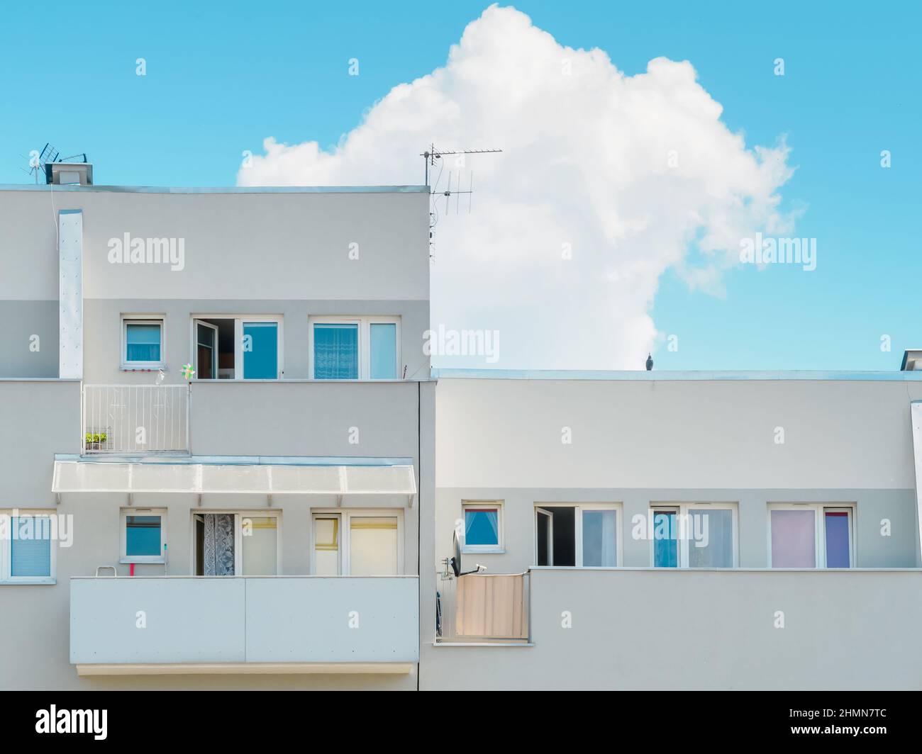 front view of modern apartment building against blue sky in a sunny day ...