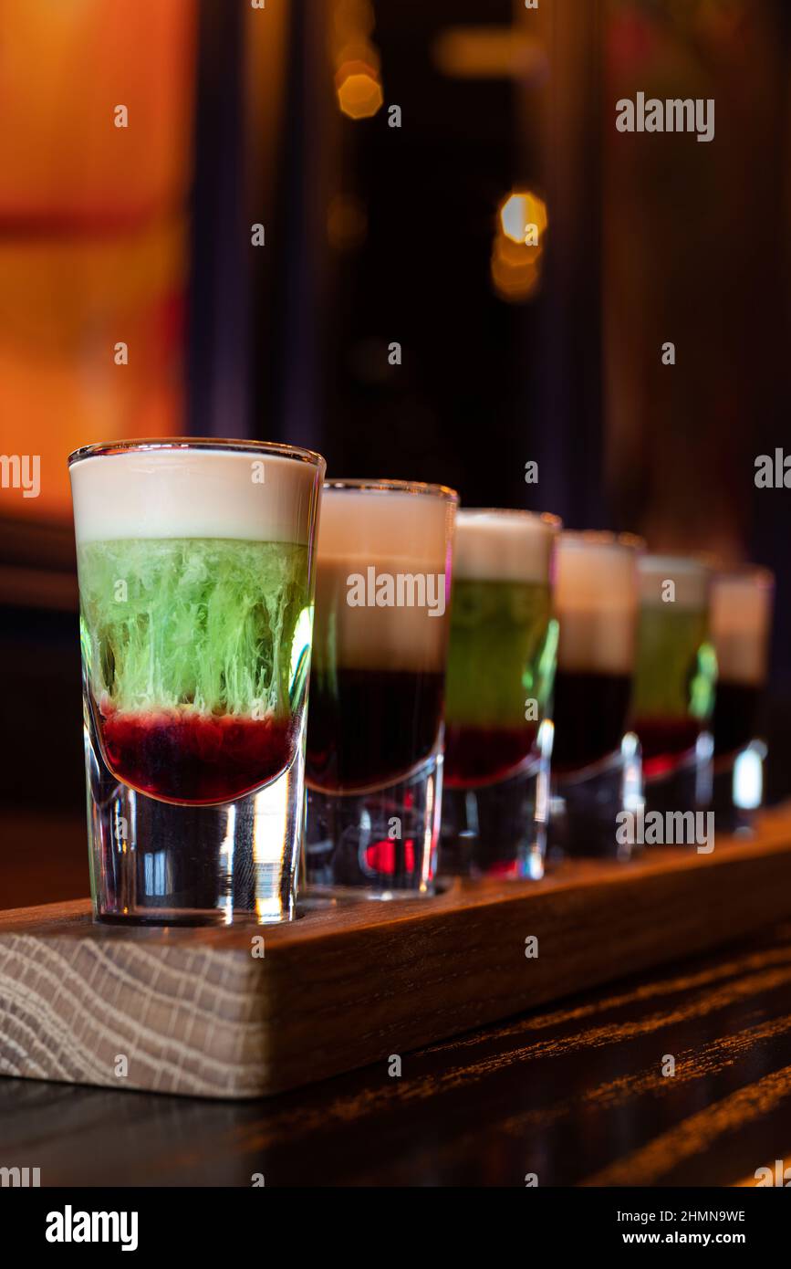 Variety of coffee and mint alcohol cocktail shots in a row at the bar ...