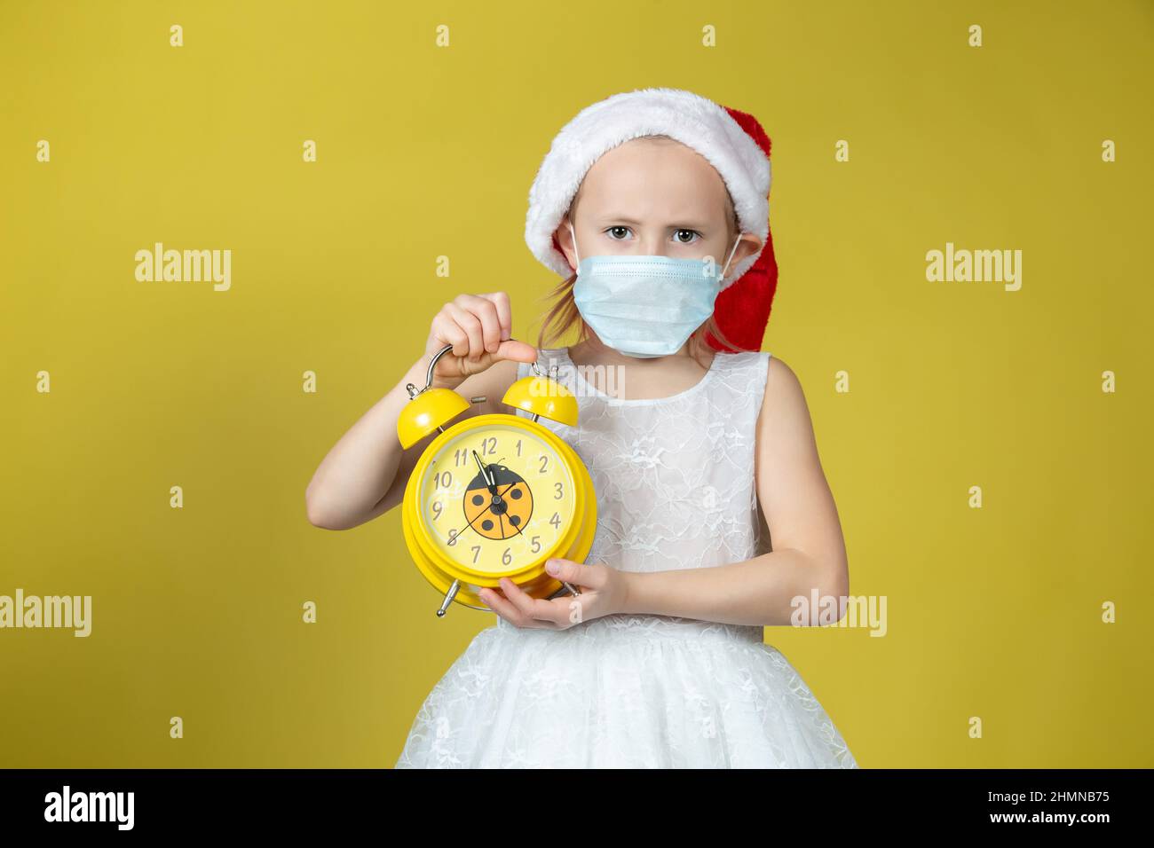 Six-year old caucasian girl with alarm clock and unhappy emotion and ...