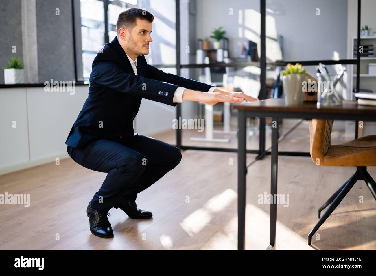 Young Fit Businessman Doing Sit-ups At Workplace Stock Photo - Alamy