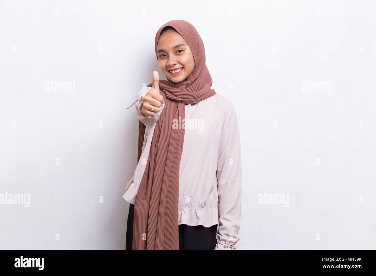 young asian beautiful muslim woman with ok sign gesture tumb up isolated on white background ...