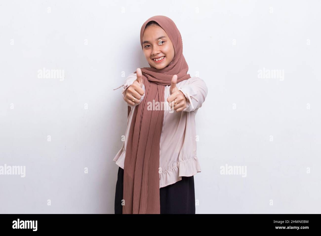 young asian beautiful muslim woman with ok sign gesture tumb up isolated on white background ...