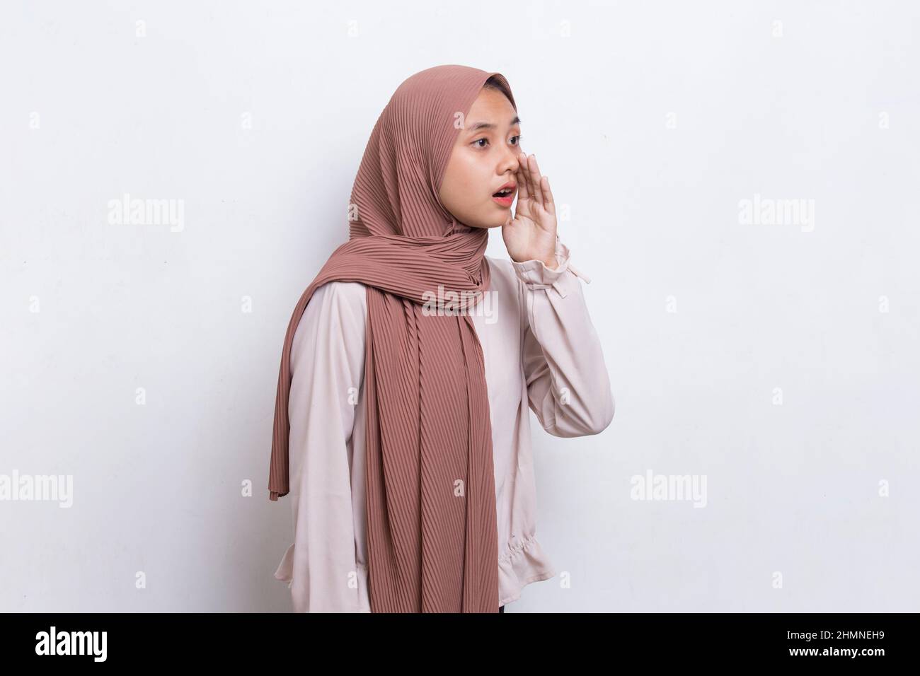 young asian beautiful muslim woman shouting and yelling announcing ...