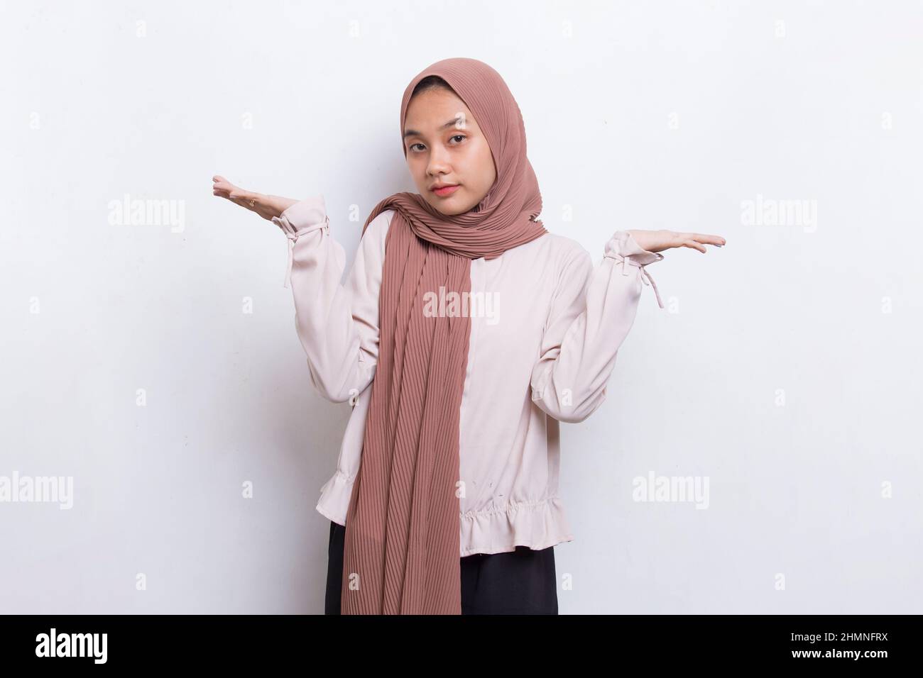 Happy young asian muslim woman pointing with fingers to different ...