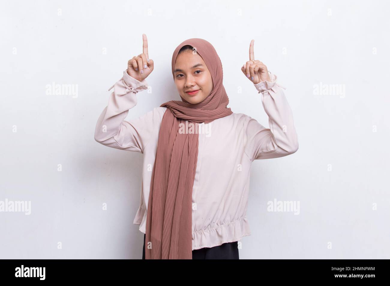 Happy young asian muslim woman pointing with fingers to different ...