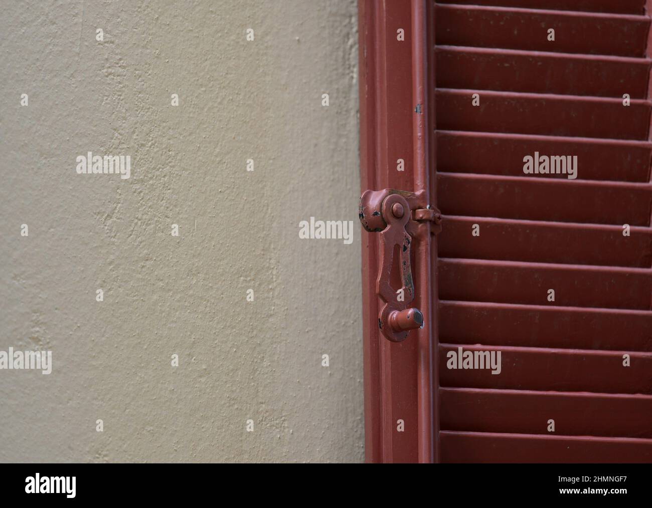 Traditional scarlet red wooden window shutter with a metal latch ...