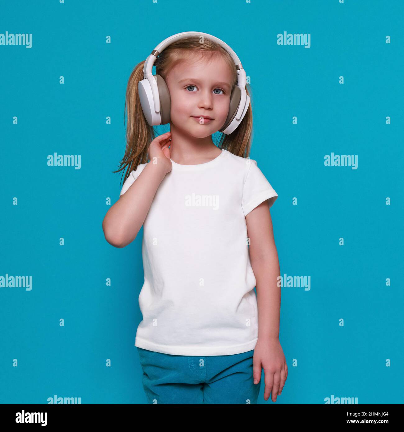 Mocap, little european girl in white t-shirt and headphones on a blue ...