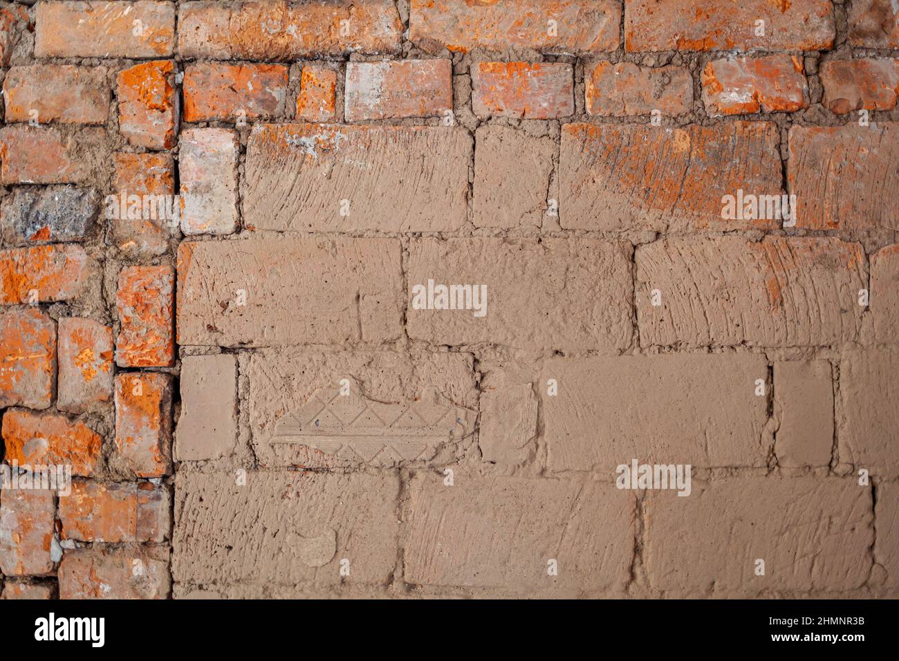 Repair of an old brick wall of a home stove. Different red bricks are ...